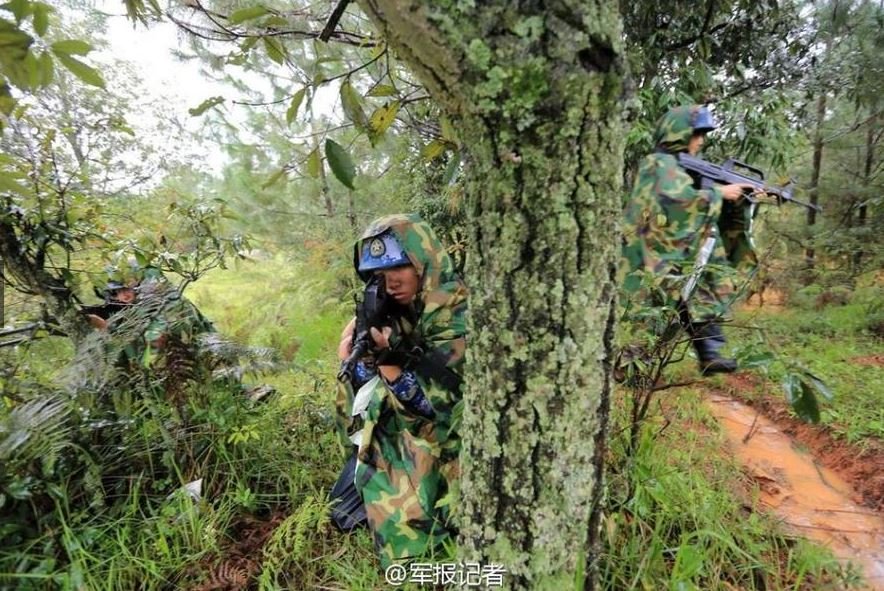Chinese marines wear blue battle fatigues in green vegetation